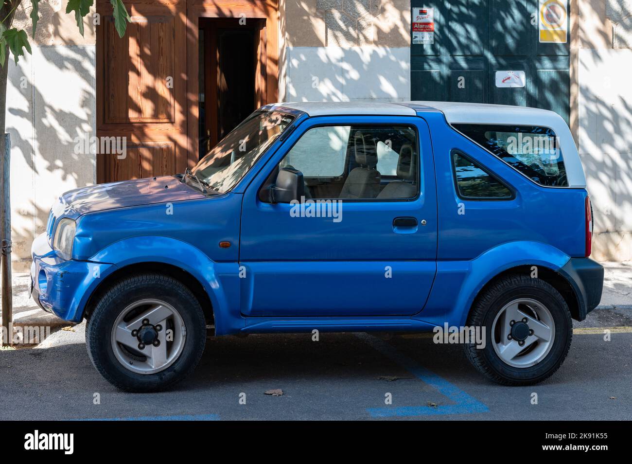 A nice blue off-road car parked on the street, Suzuki Jimny side view ...