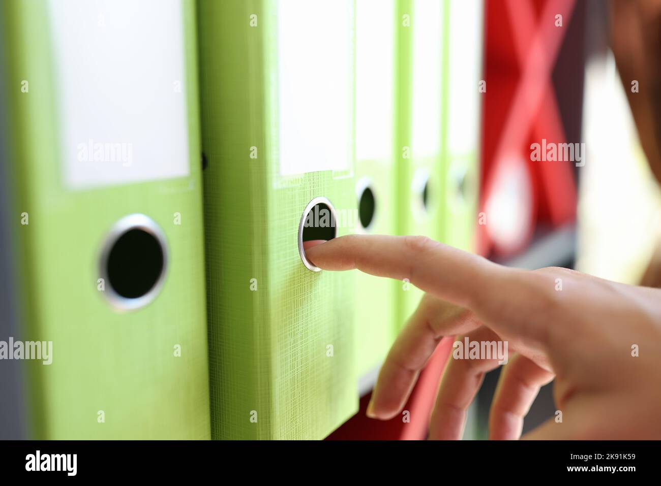 Woman hand taking off green folder with documents from shelf Stock ...