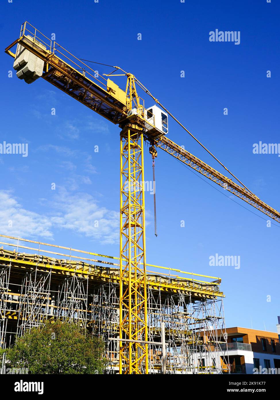 Yellow construction tower crane and concrete formwork with a folding ...