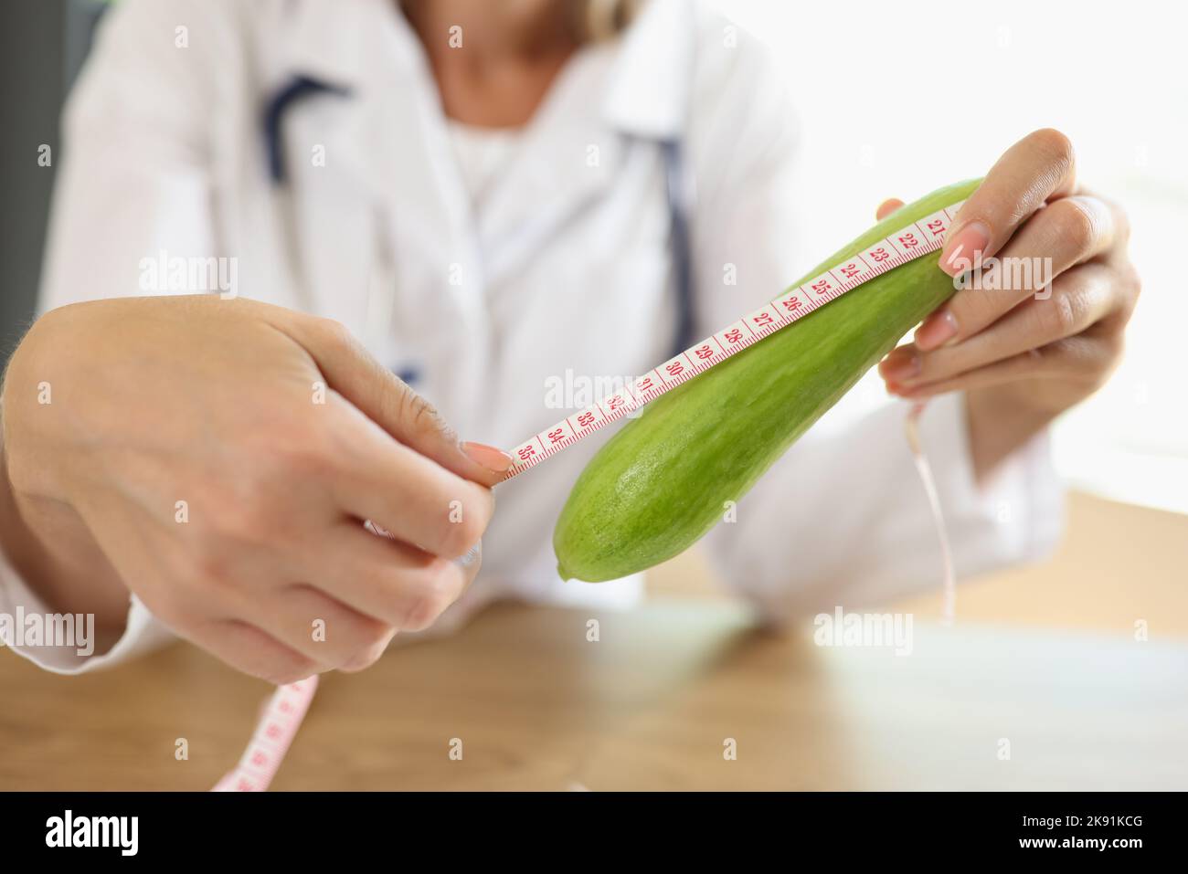 Woman nutritionist measuring size of squash or zucchini with measuring ...
