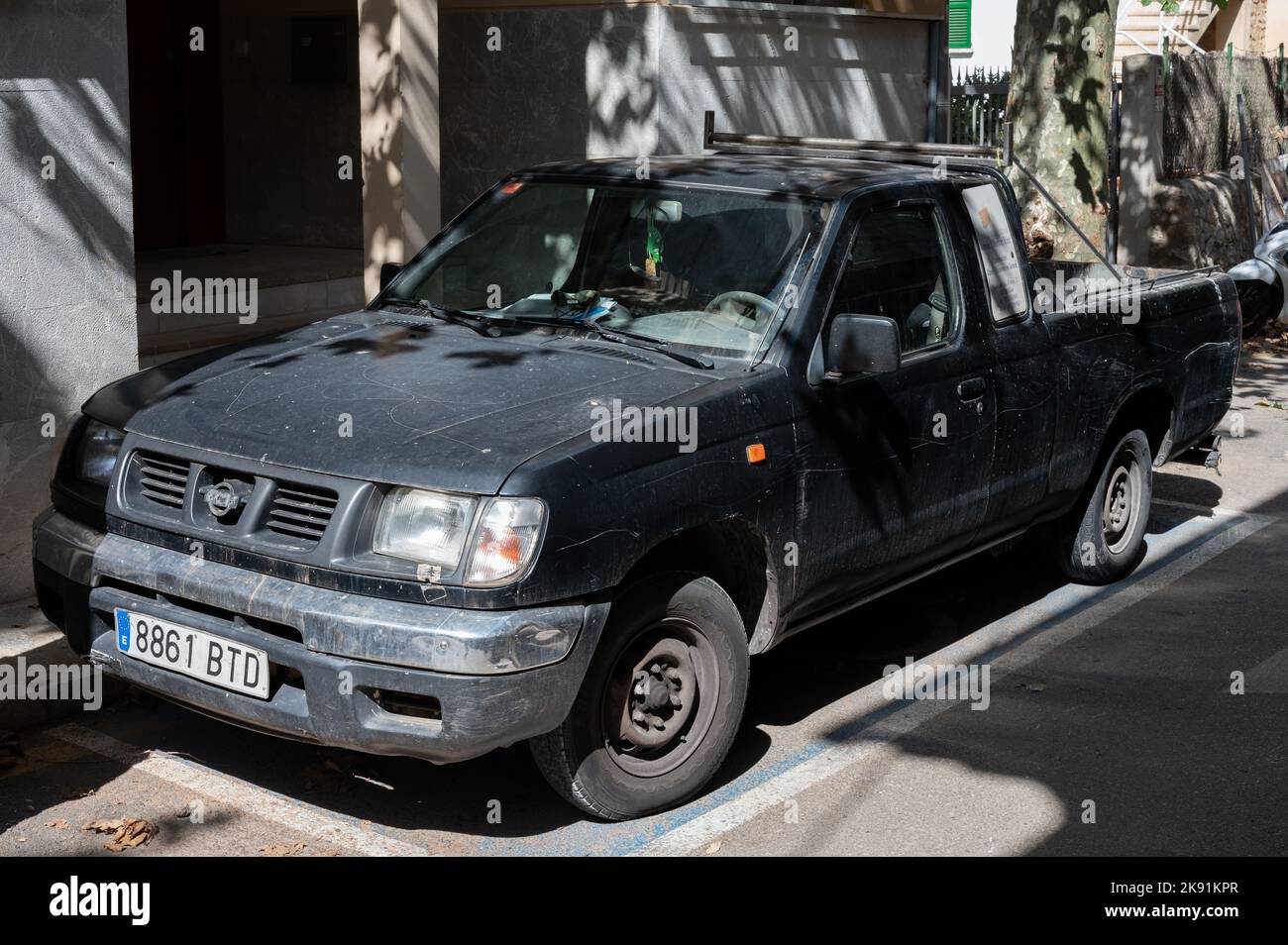 An old all-terrain first generation black Nissan Navara car parked on ...