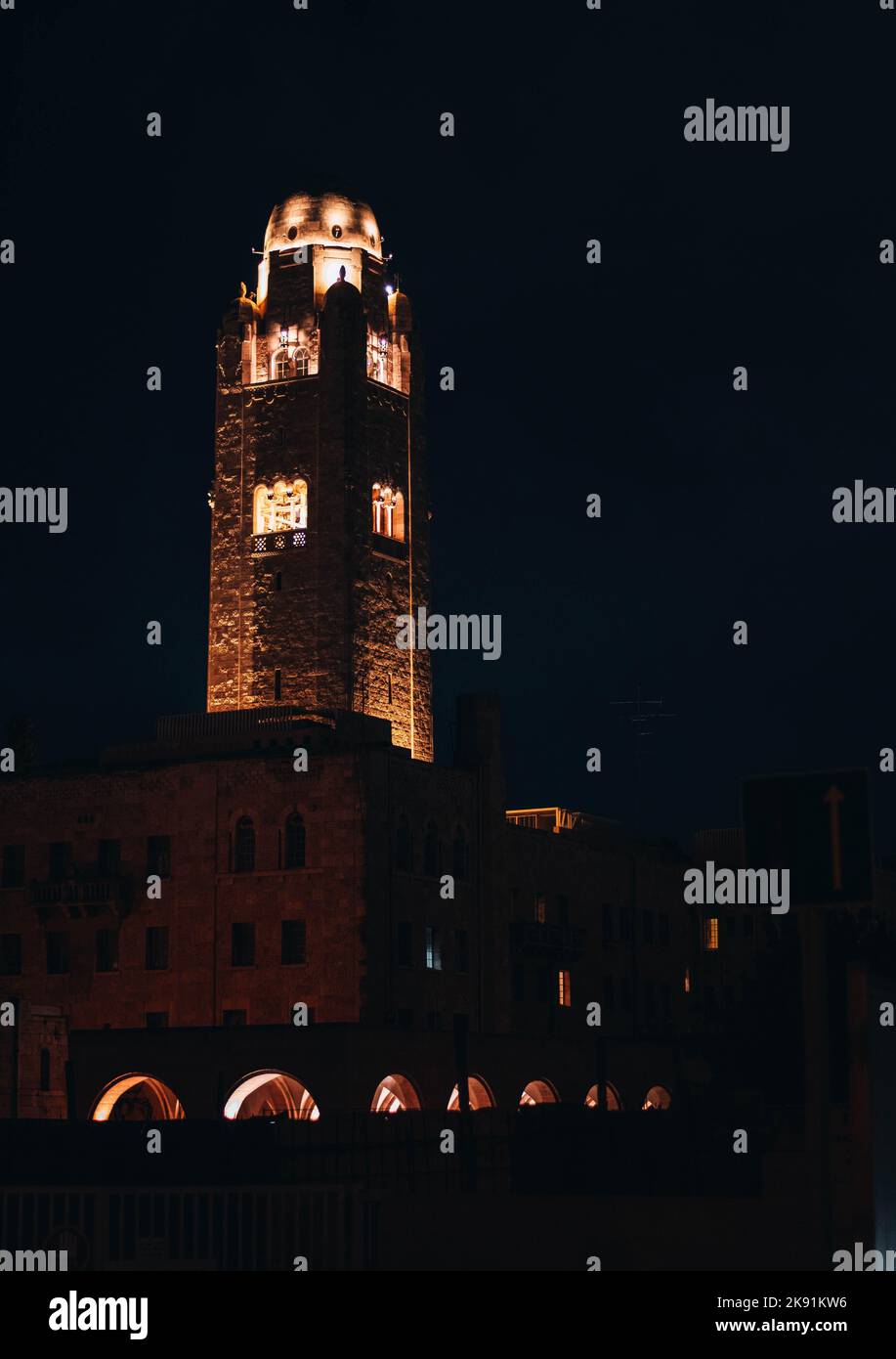 A vertical shot of a beautiful illuminated tower building at night ...
