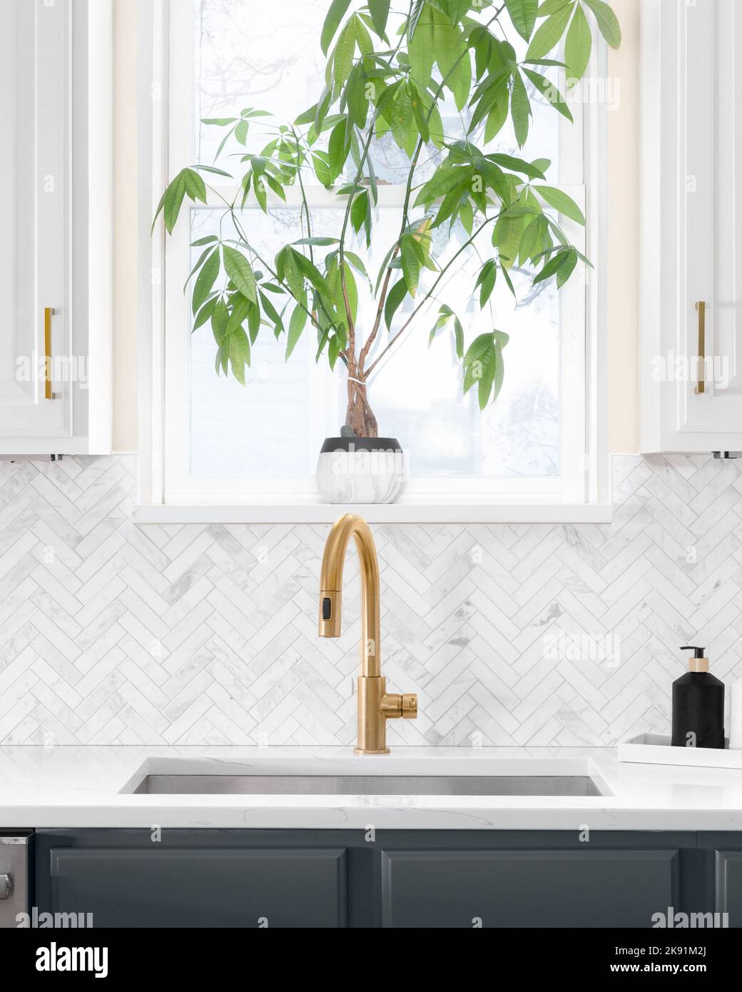 Sink detail shot in a luxury kitchen with herringbone backsplash tiles ...
