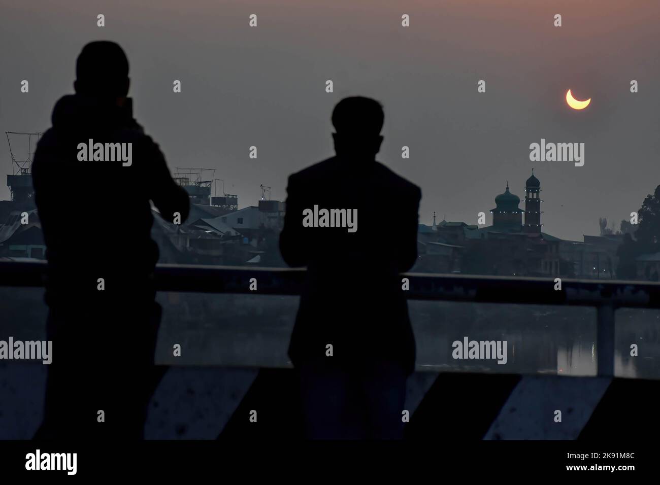 Residents watch as a partial solar eclipse begins in Srinagar. The ...