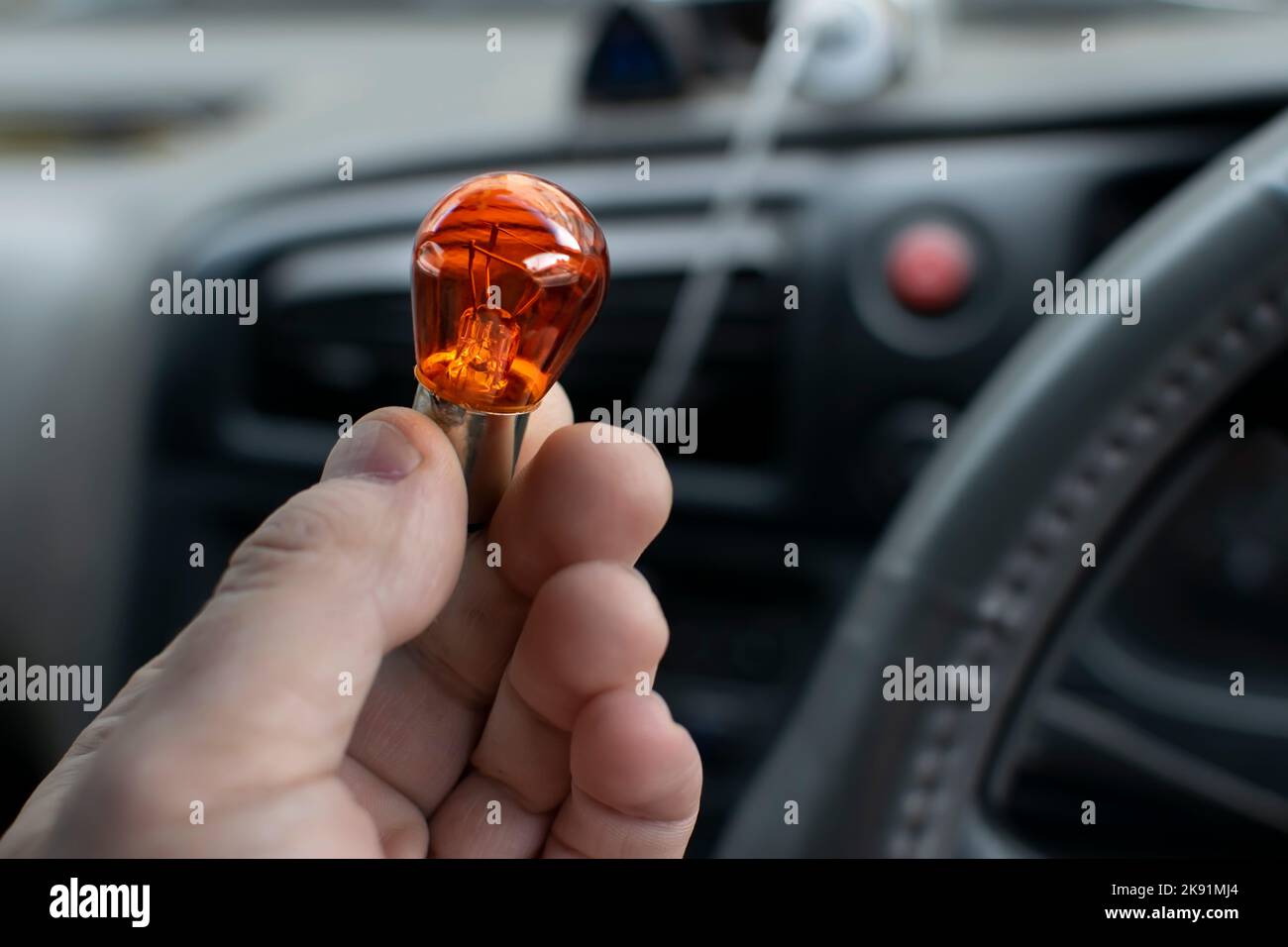 new car warning light of the old type in the hand of a person, the ...