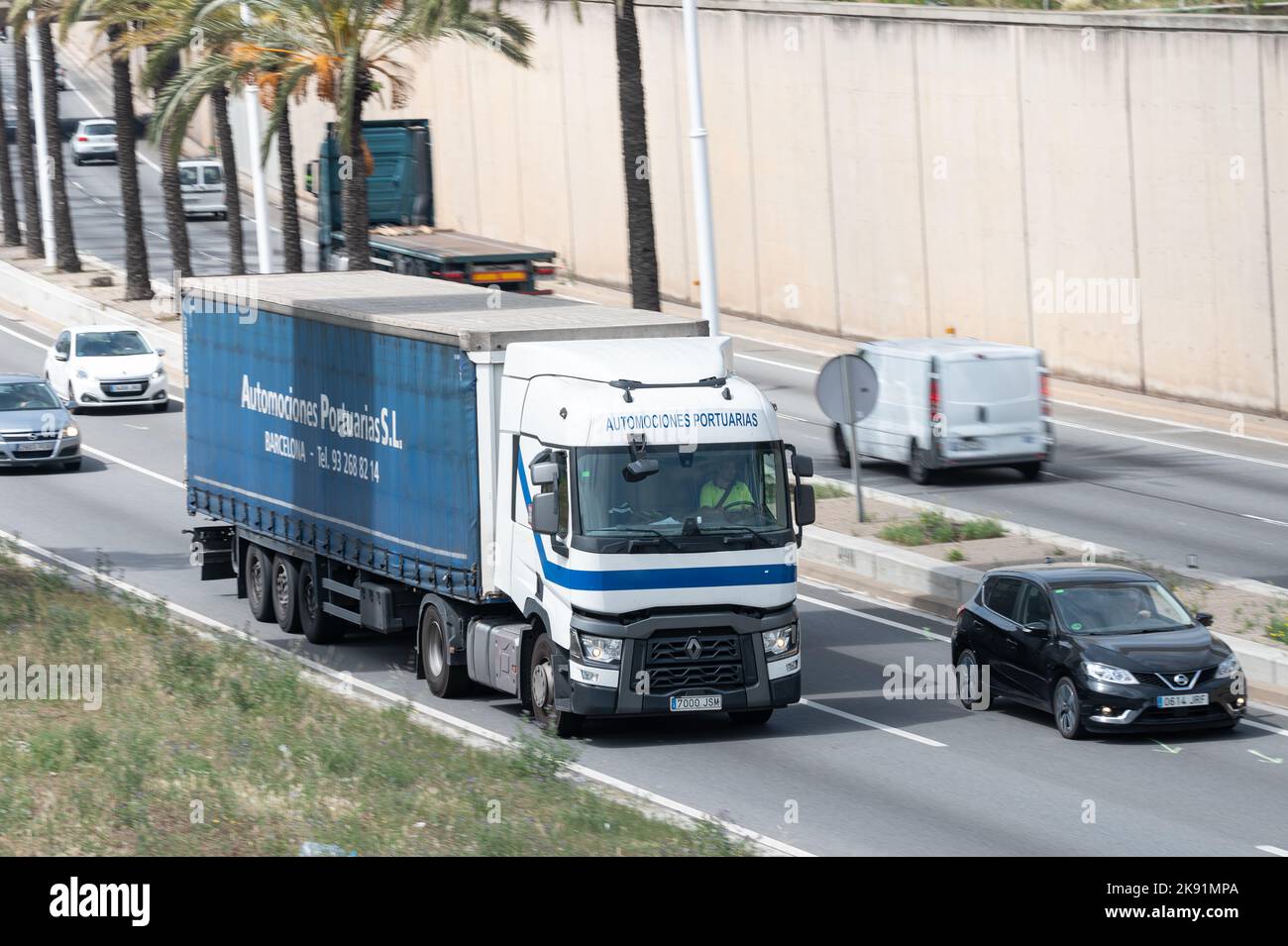 White Renault Magnum truck loading a blue container trailer along ...