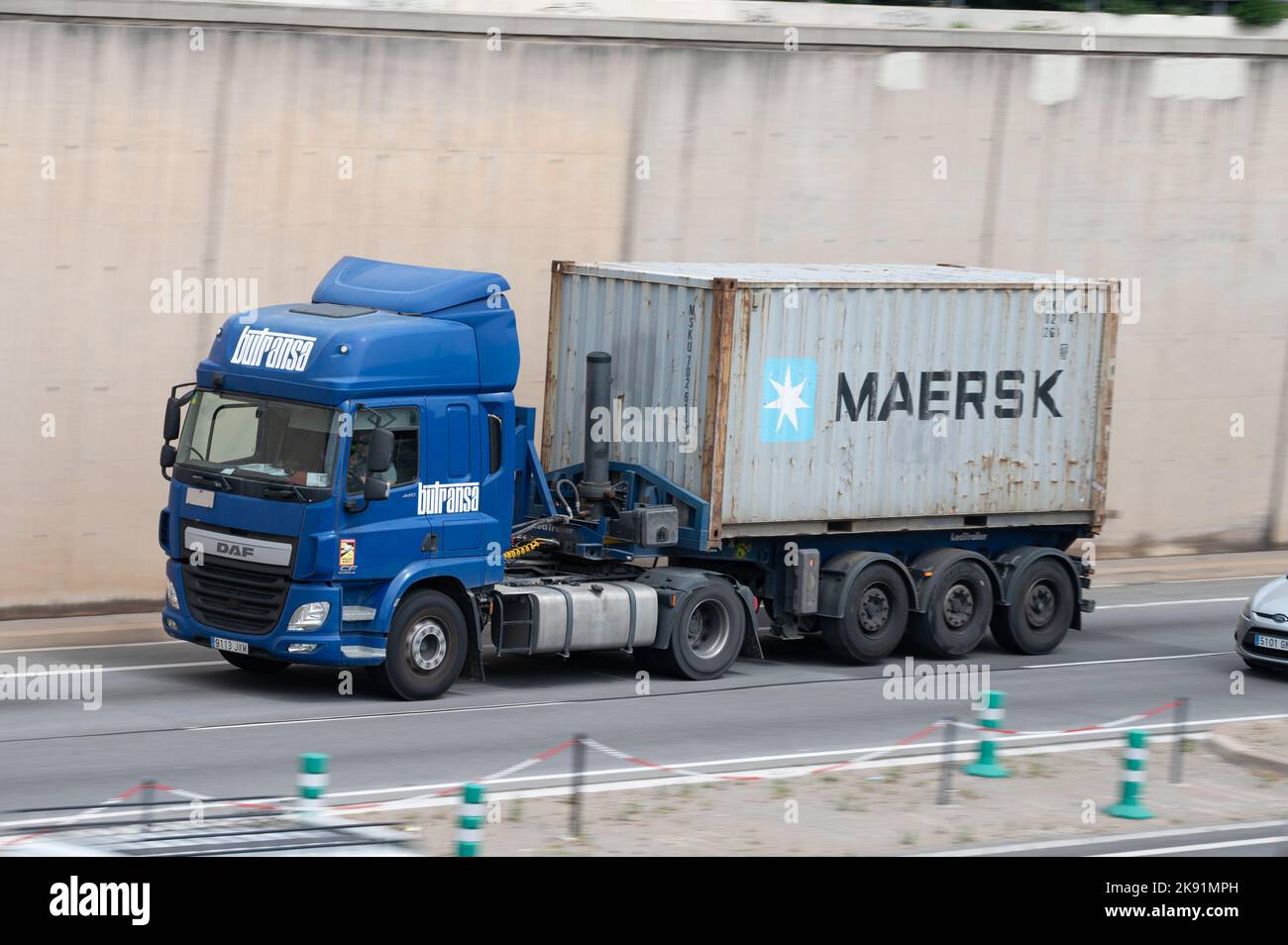 A blue DAF CF truck loading a gray container trailer along Barcelona's ...