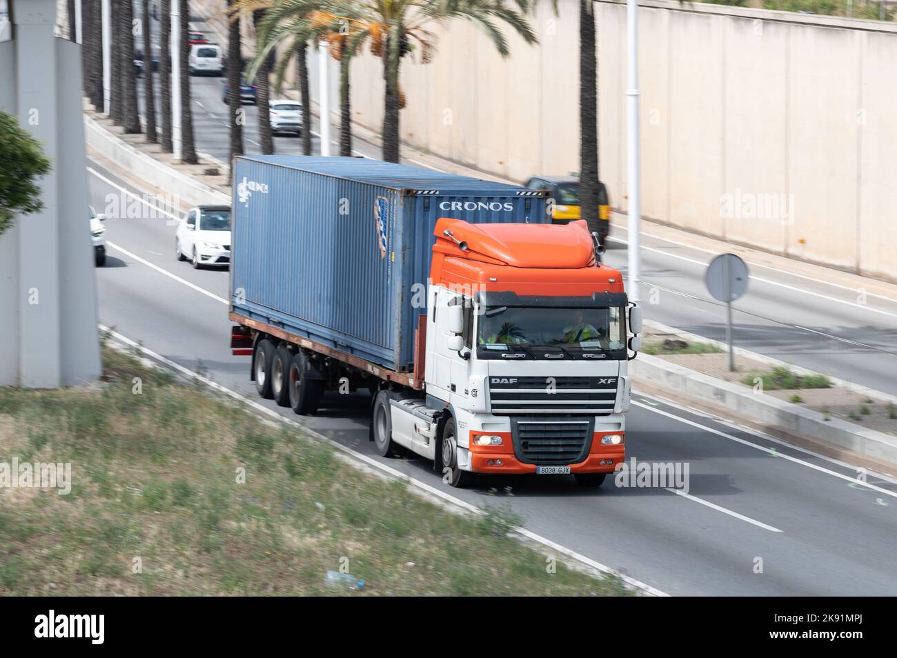 White and orange DAF XF truck loading a blue container trailer along ...