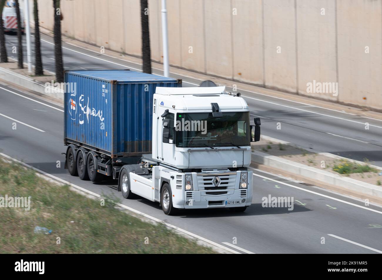 White Renault Magnum truck loading a blue container trailer along ...