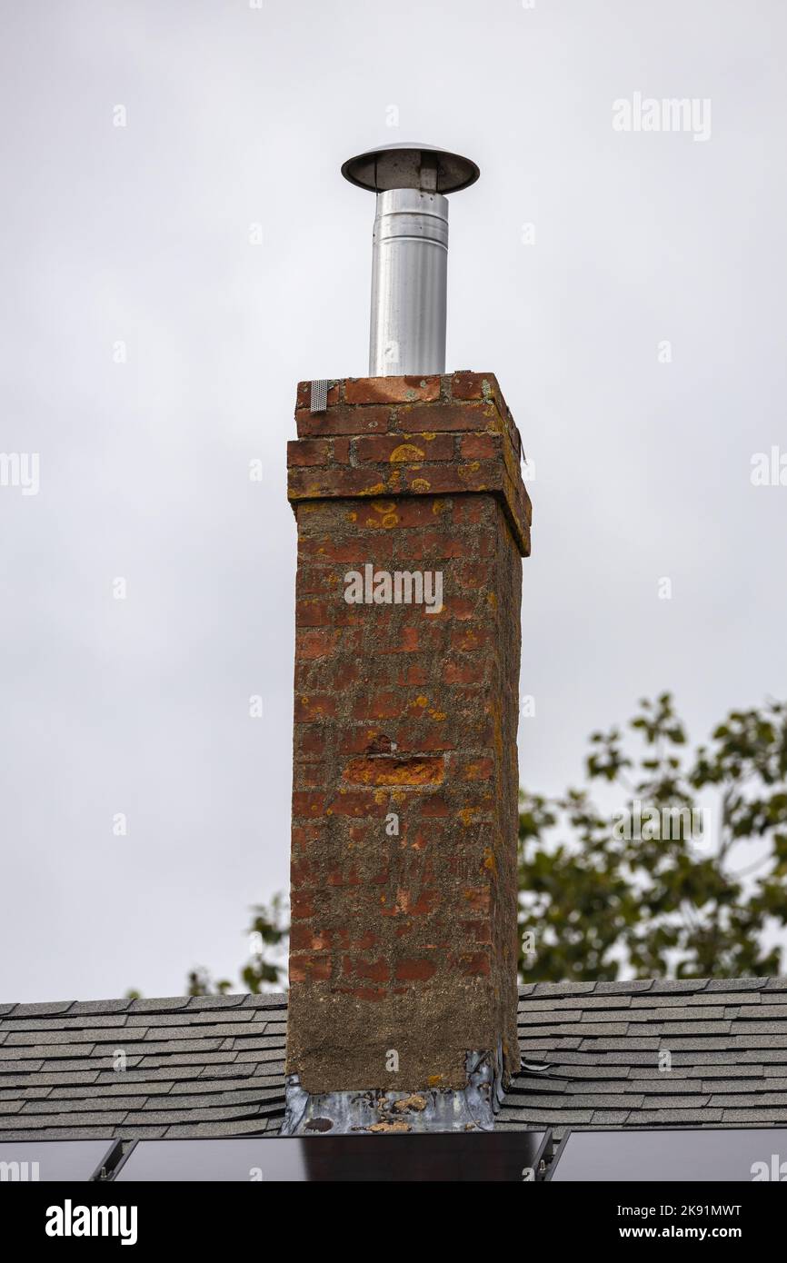 A vertical of a chimney and solar panels on an old New England home ...