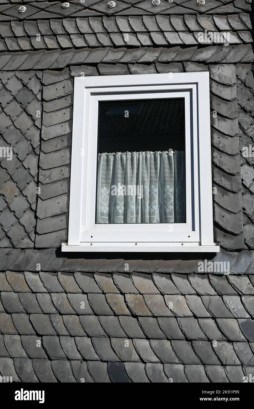 Gray slate wall siding on a house with a white window Stock Photo - Alamy