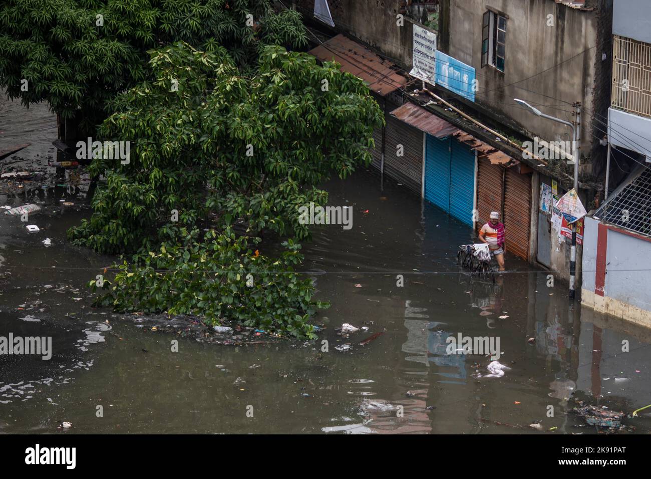 A man walks through a waterlogged street following heavy rains causing ...