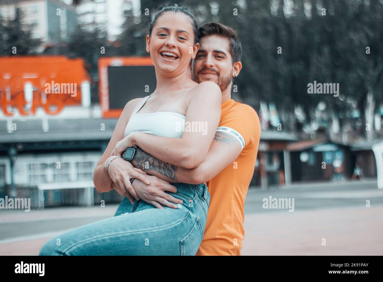 A shallow focus shot of a Caucasian male carrying his female lover ...