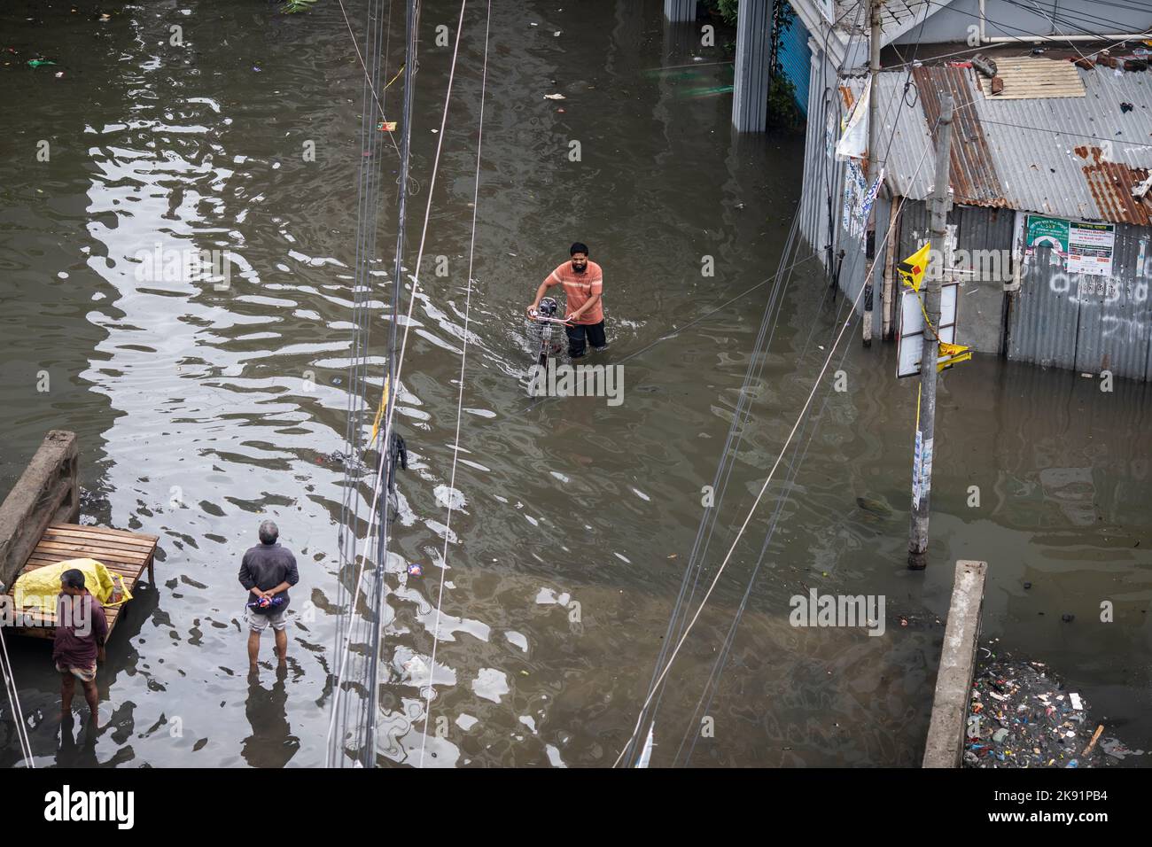 A man moves through a waterlogged street following heavy rains causing ...