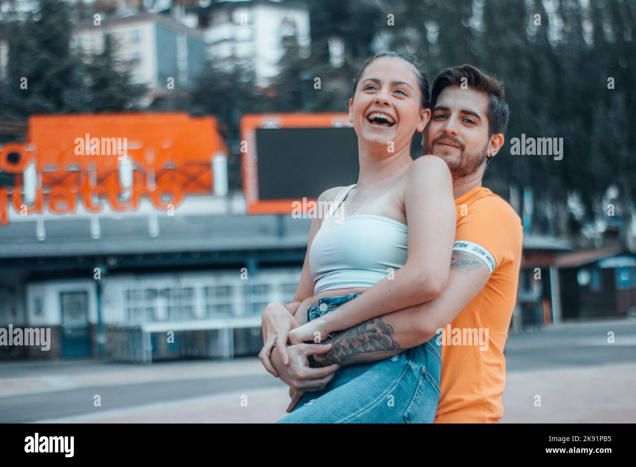 A shallow focus shot of a Caucasian male carrying his female lover ...