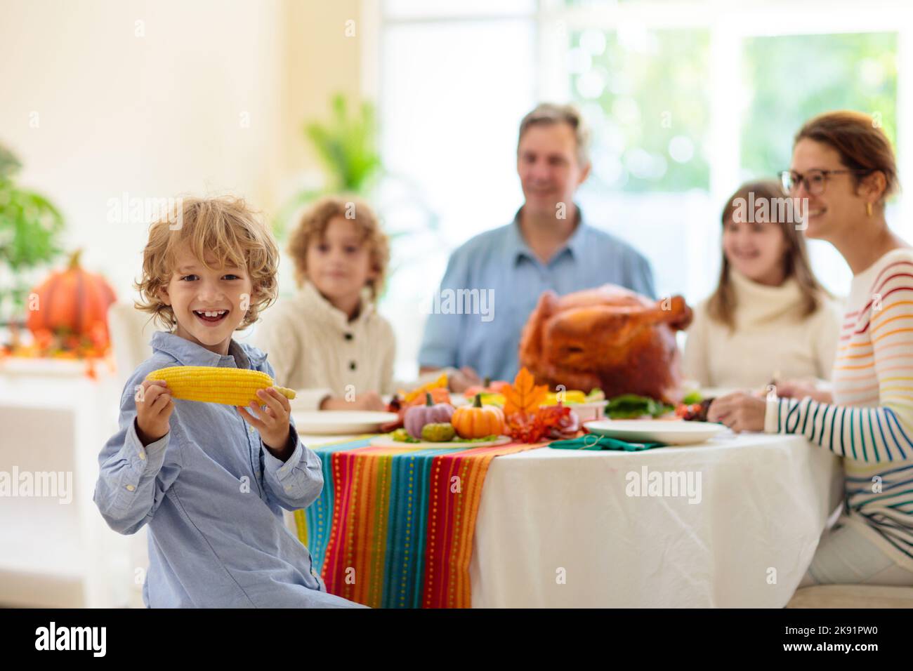 Family at Thanksgiving dinner. Parents and kids enjoy roasted turkey ...