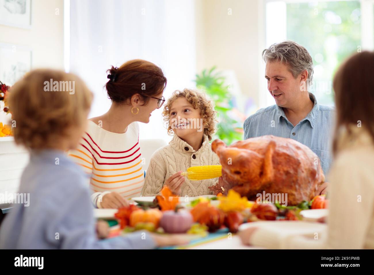 Family at Thanksgiving dinner. Parents and kids enjoy roasted turkey ...