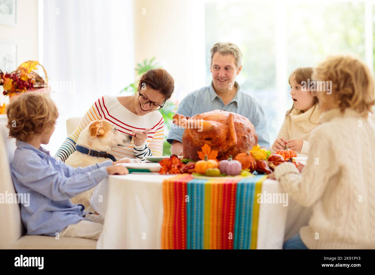 Family at Thanksgiving dinner. Parents and kids enjoy roasted turkey ...