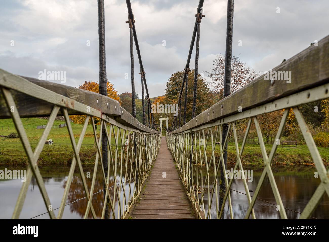 Looking along the Hebden Suspension Bridge which spans the River Wharfe ...