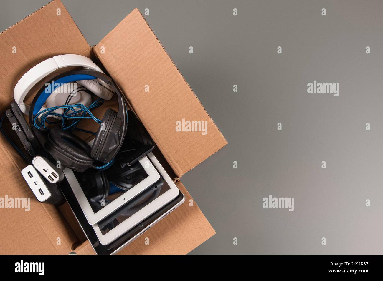 Cardboard box full of old used computers, digital tablets, smartphones ...
