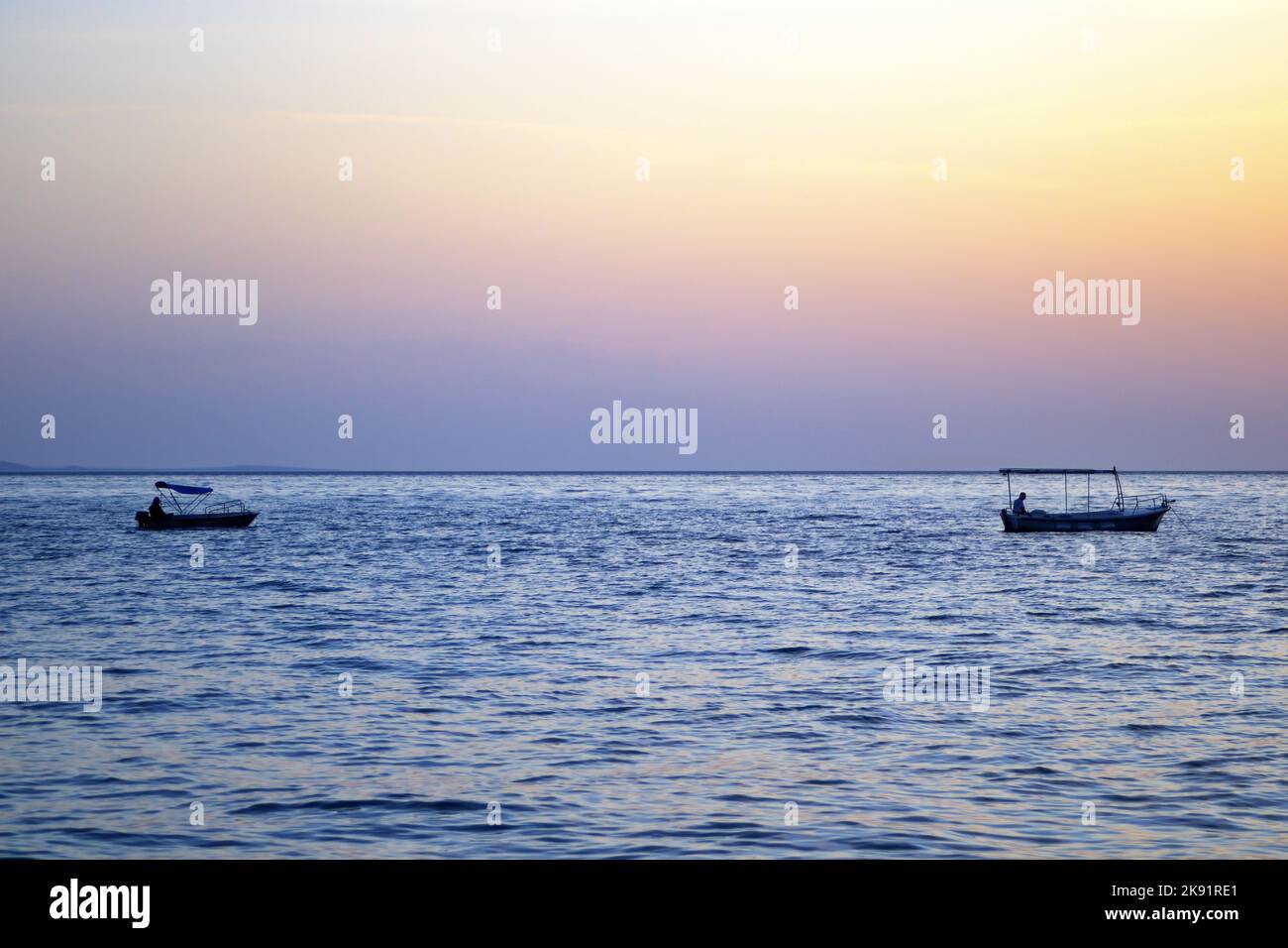 A beautiful yellow blue sunset sky over a sea with sailing boats Stock ...