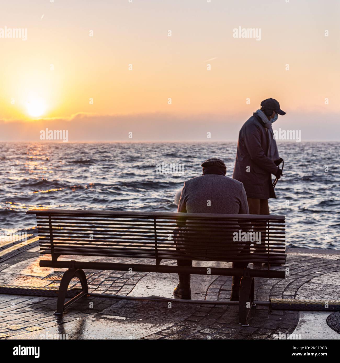 man sitting alone on a bench in front of the lake Stock Photo - Alamy