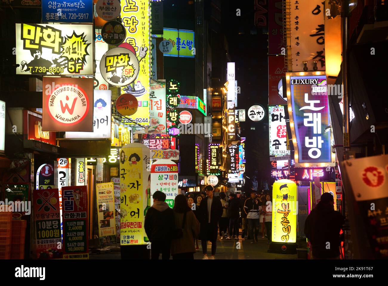A closeup of people walking at night in downtown Seoul, South Korea ...