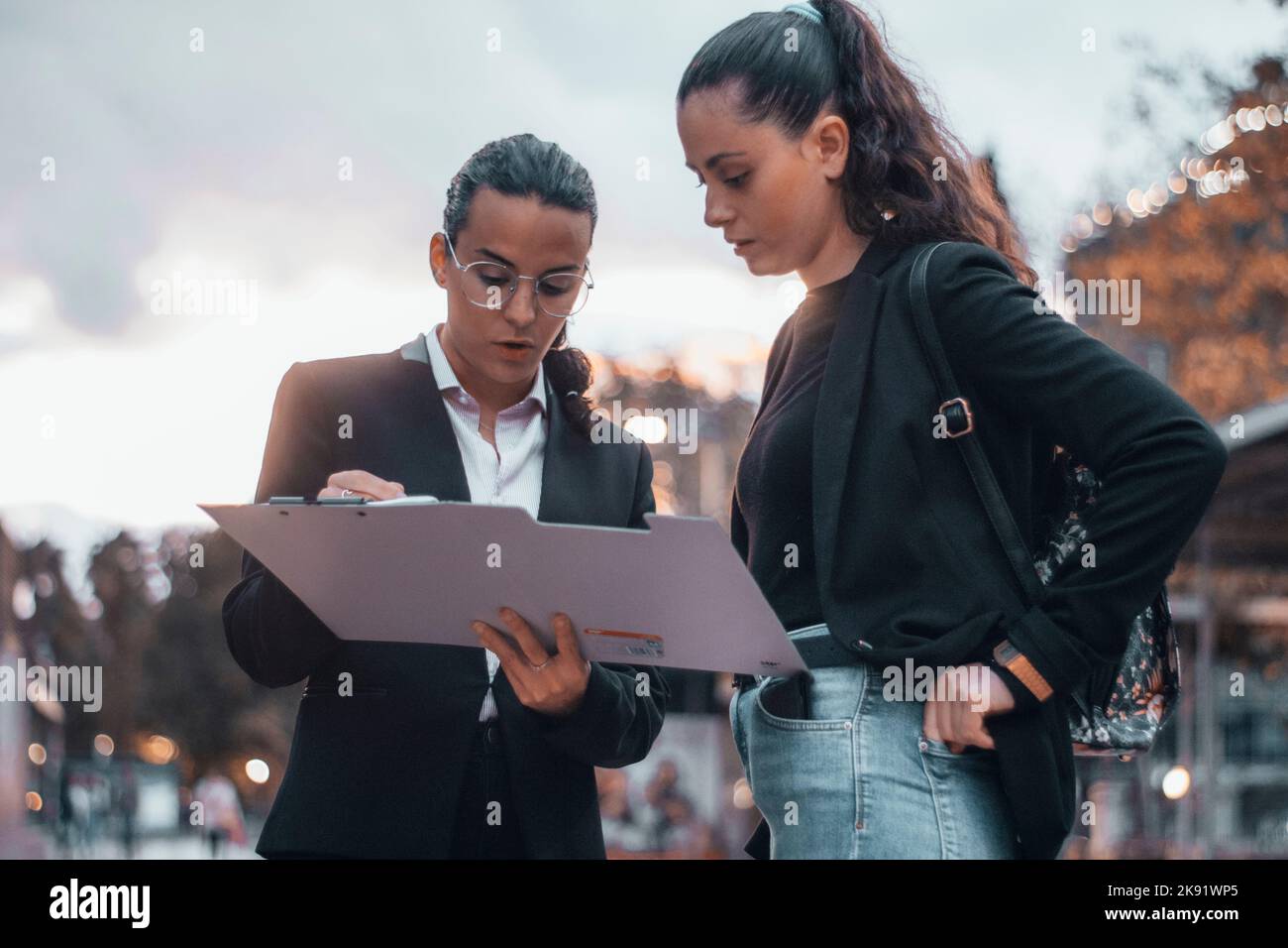 The view of two female students checking on a task while standing ...