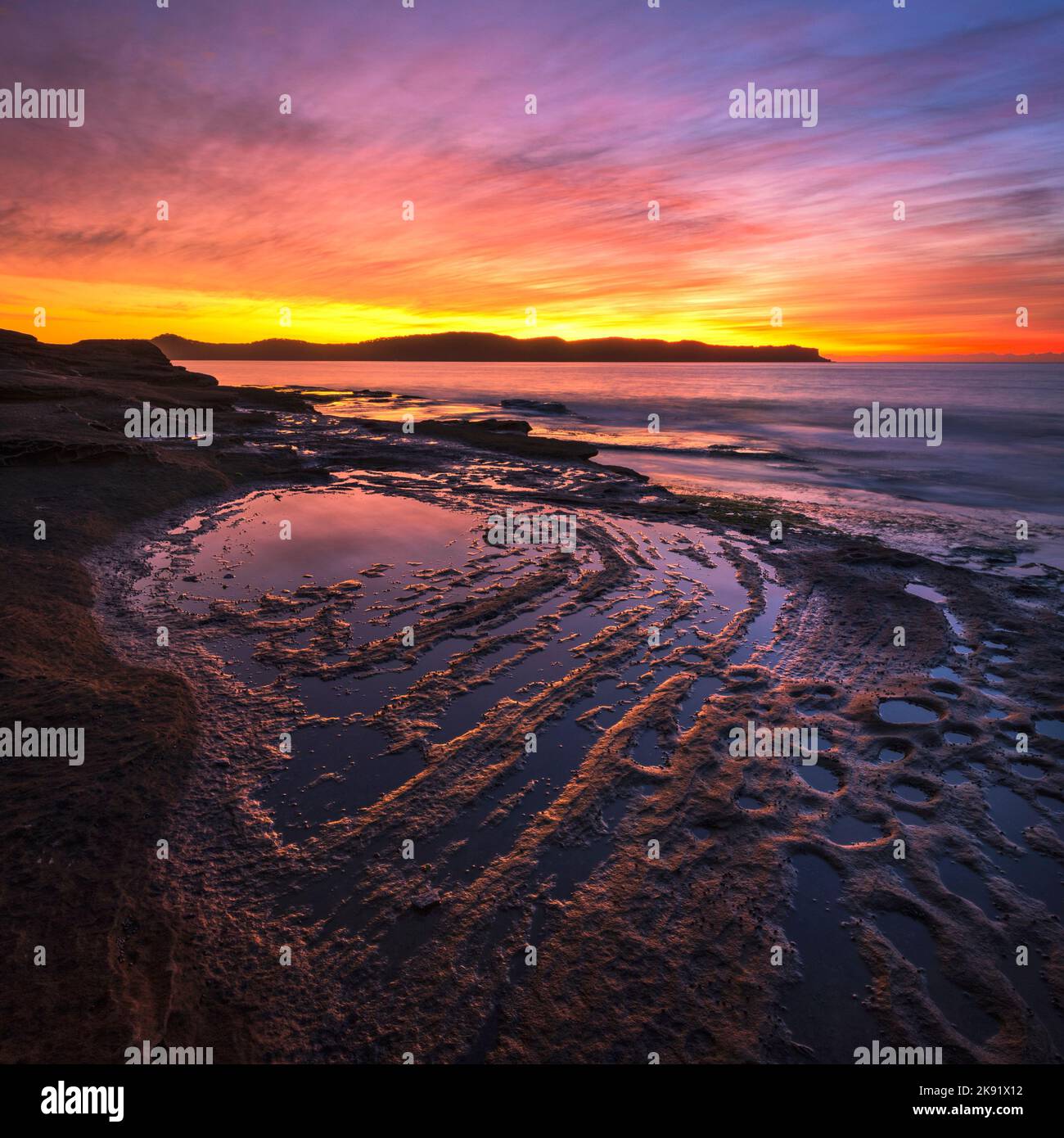 A beautiful bright sunrise over Kiddies Corner on Umina Beach on NSW ...