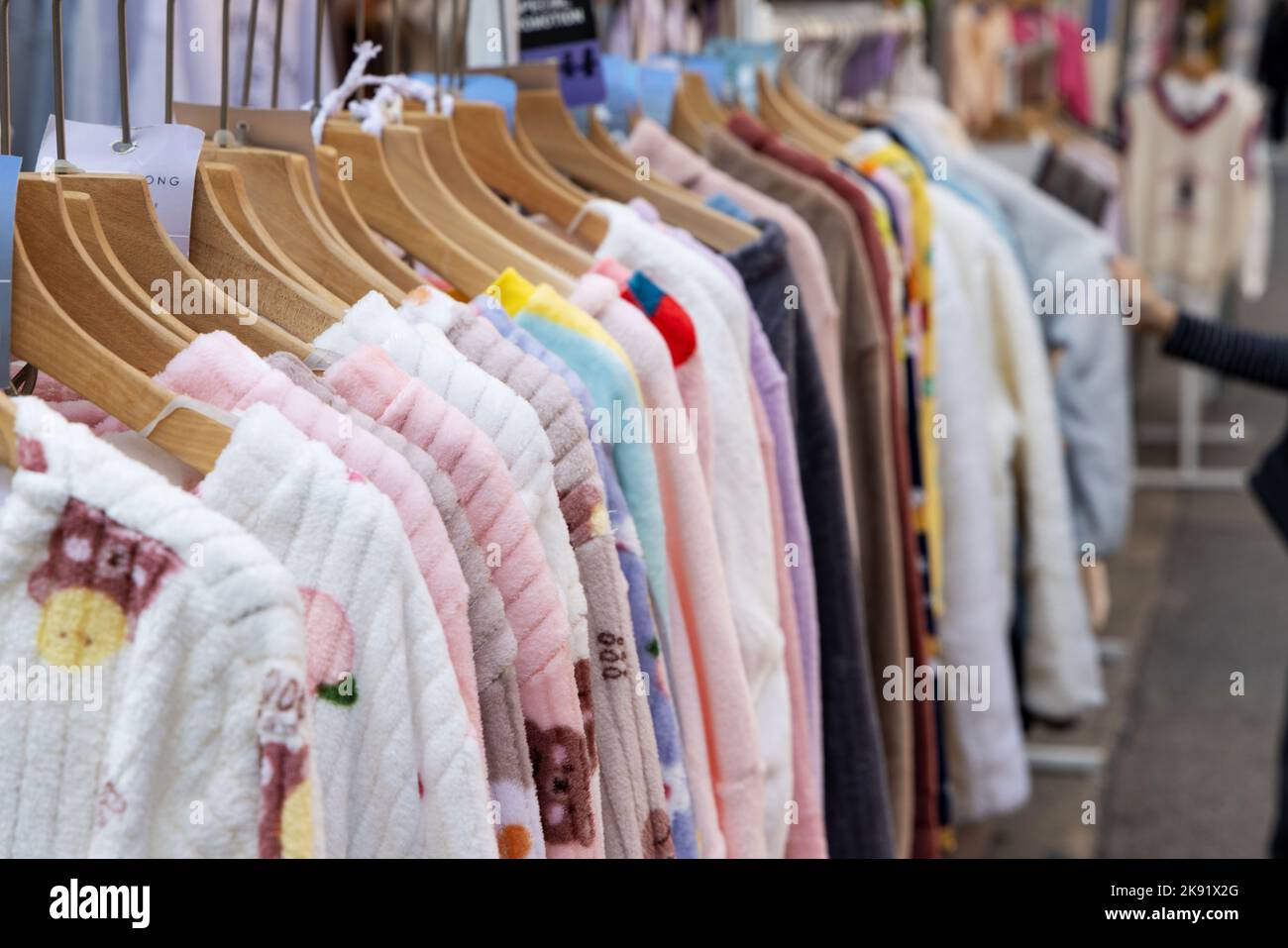 A shopping rank filled with clothes, pajamas and robes. Bunch of ...