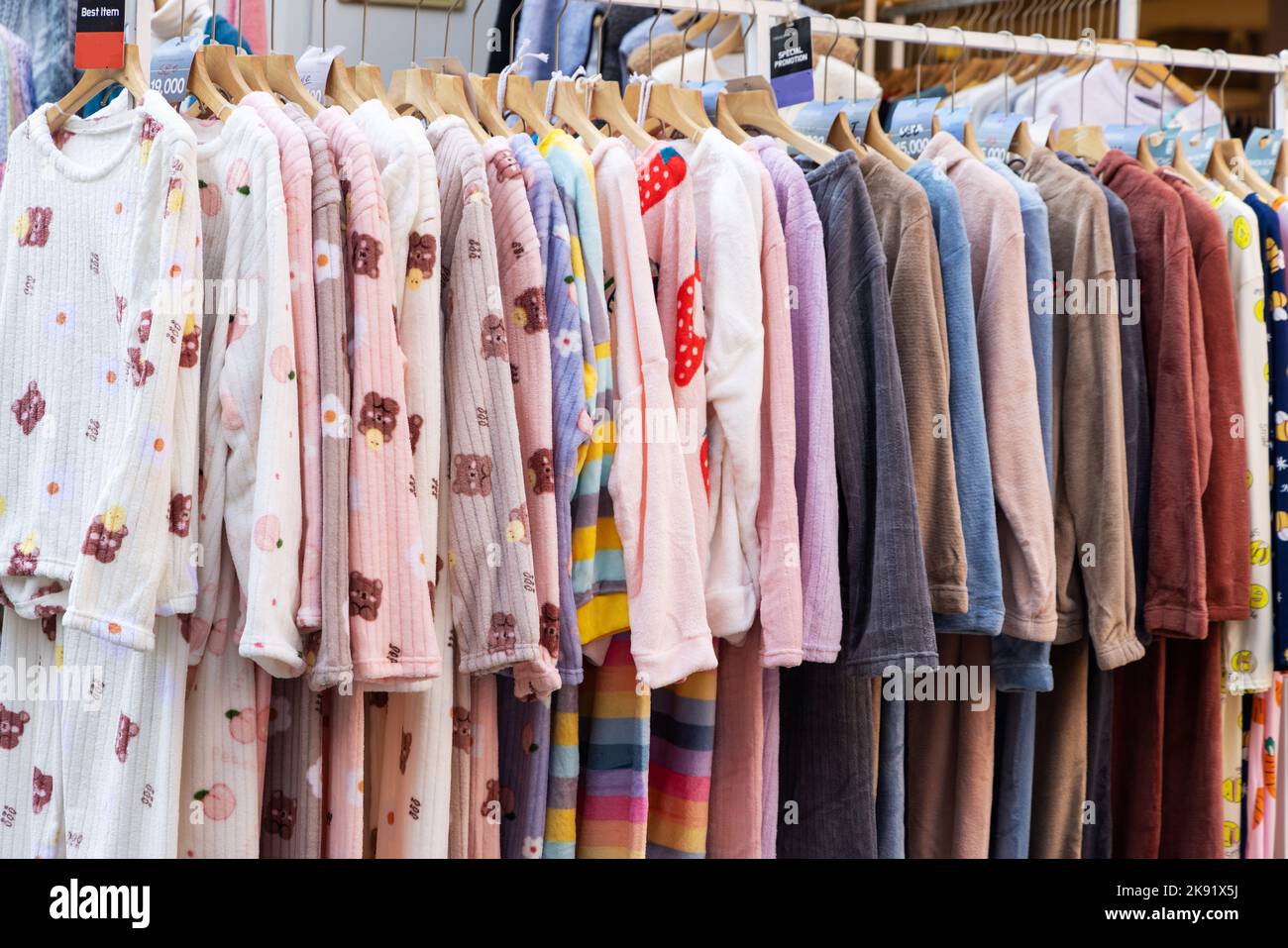 A shopping rank filled with clothes, pajamas and robes. Bunch of ...