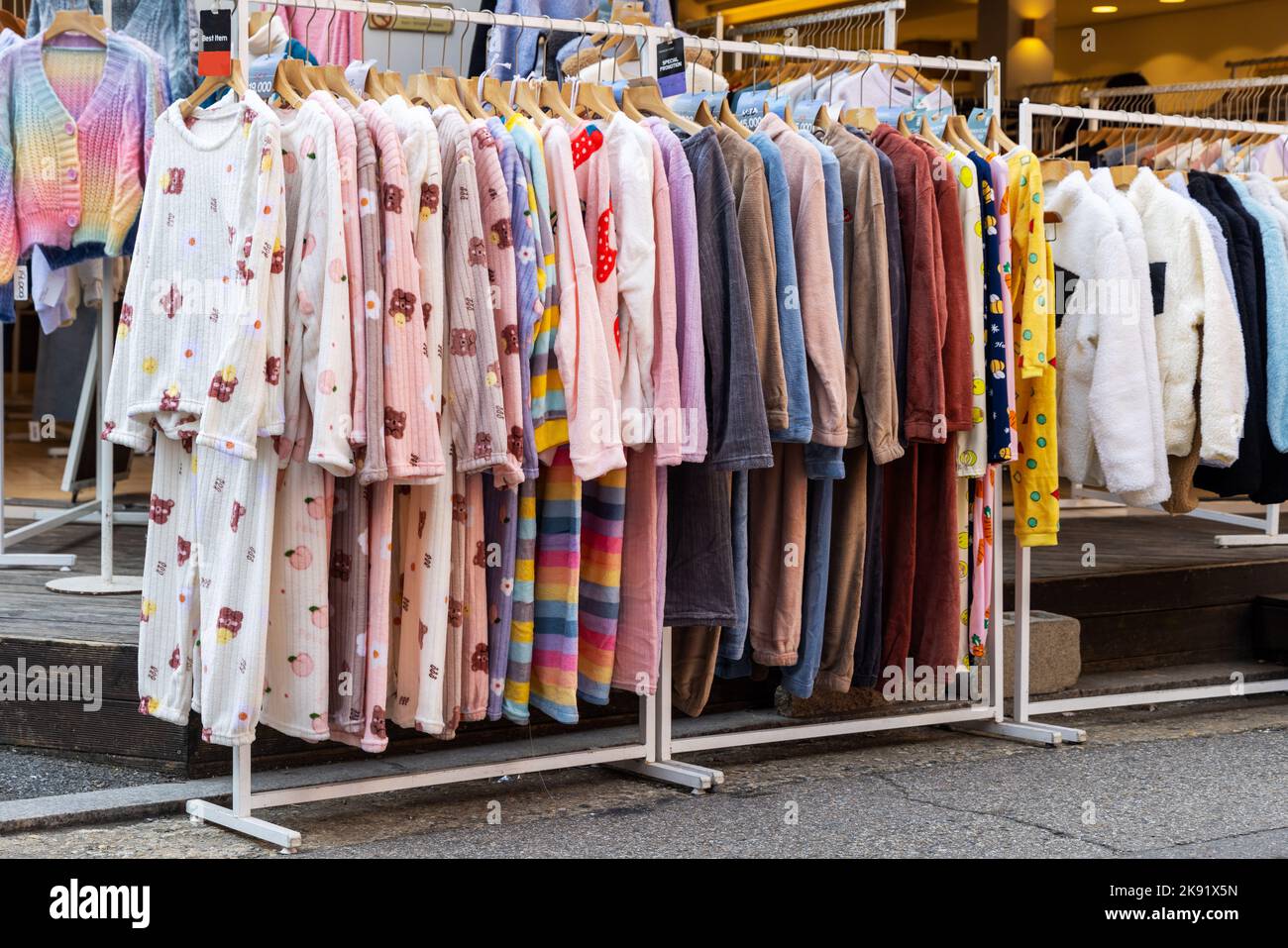 A shopping rank filled with clothes, pajamas and robes. Bunch of ...