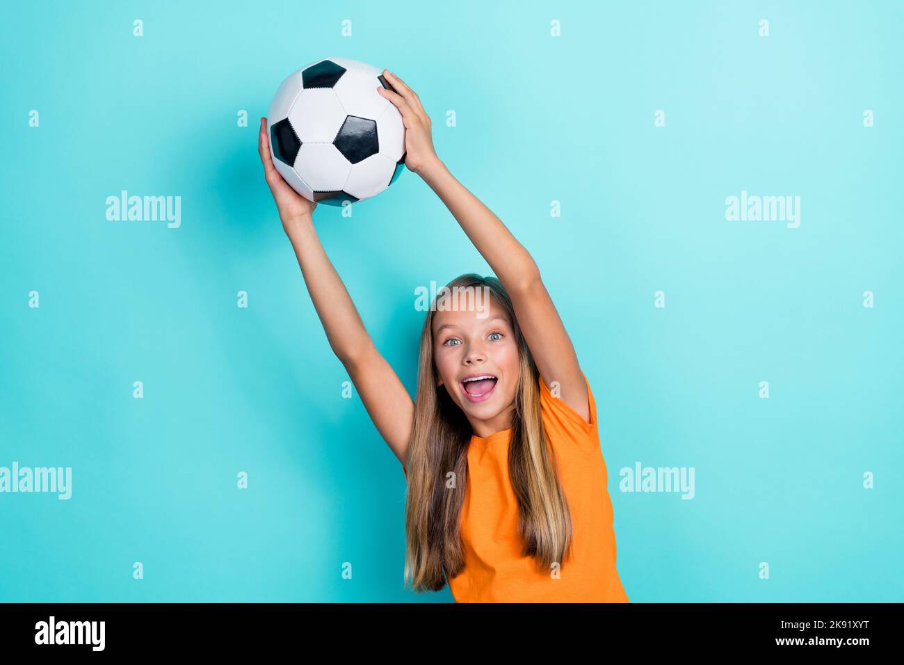 Photo of cute small charming blonde hair excited catching football ball ...