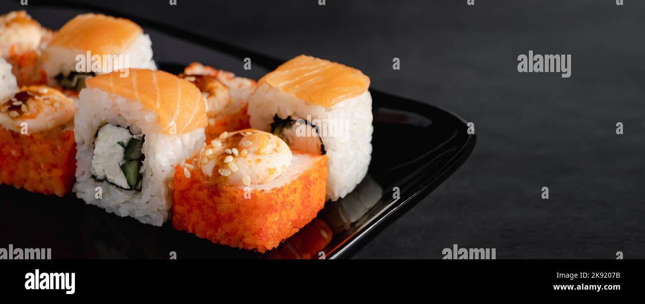 Set of Philadelphia sushi rolls on black plate. Serving Japanese food ...
