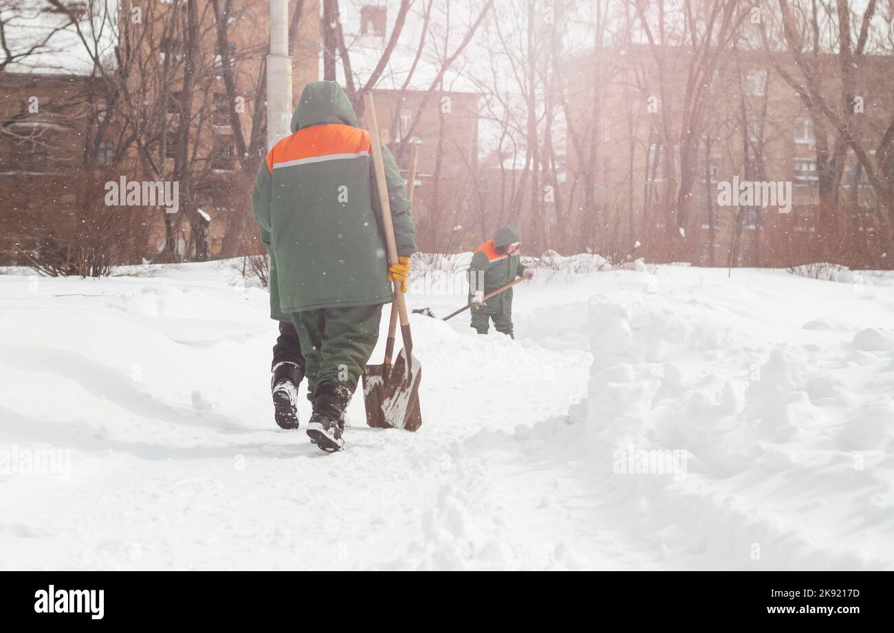 workers clean snow after winter storm Stock Photo - Alamy