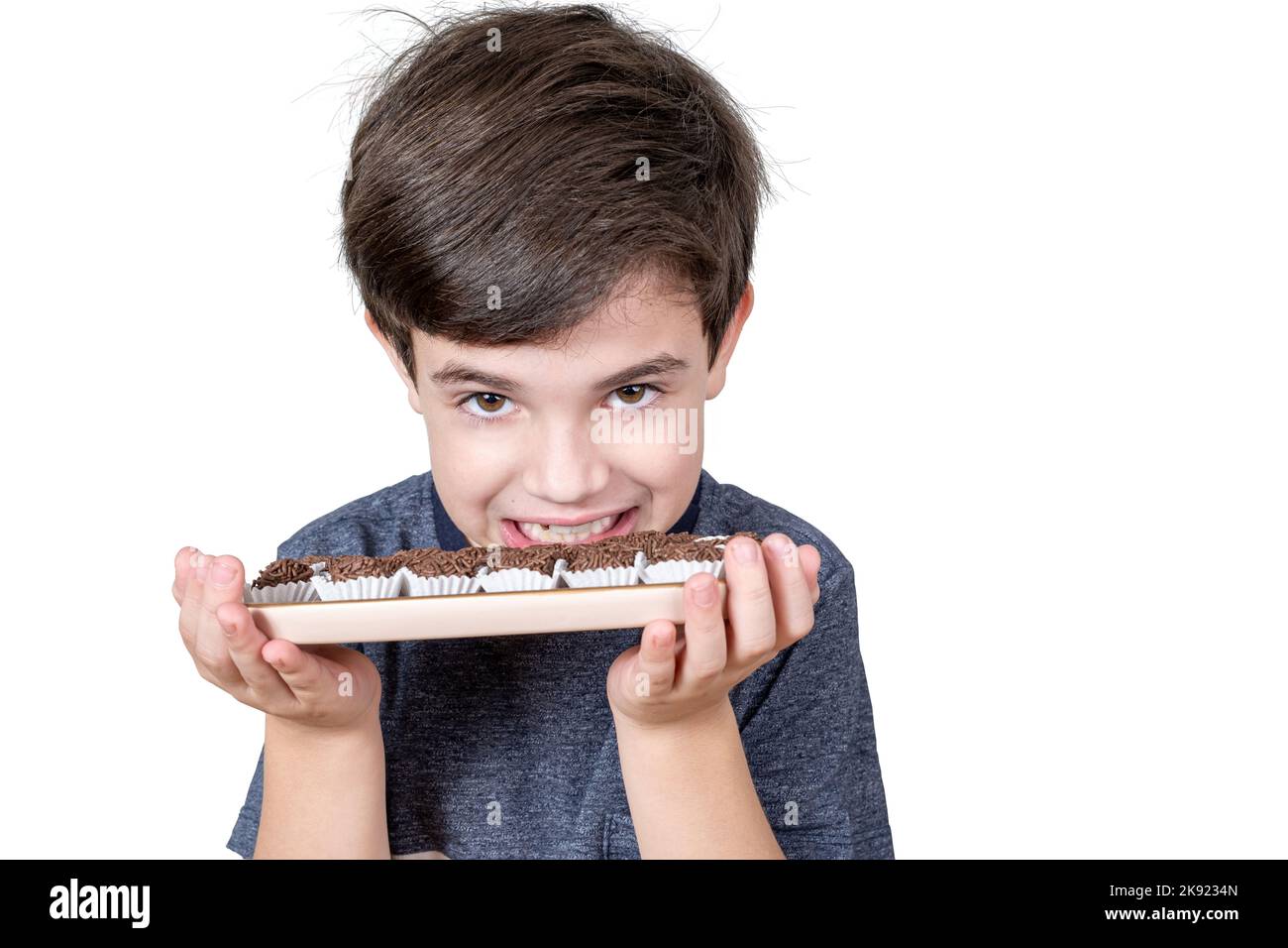 9 year old boy showing his teeth and holding a tray with several ...