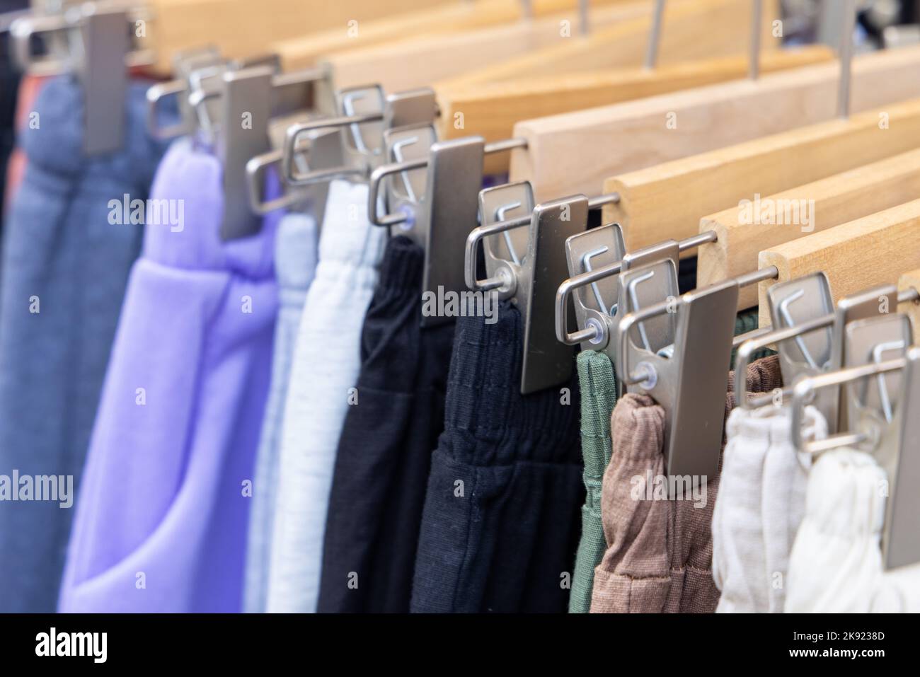 A shopping rank filled with clothes, pants, sports clothes. Bunch of ...