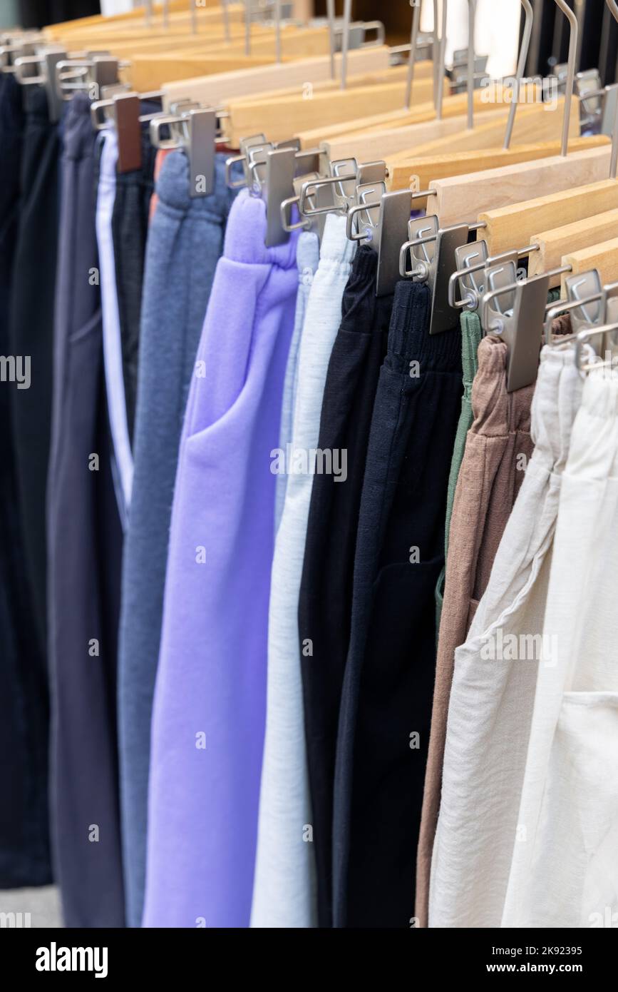 A shopping rank filled with clothes, pants, sports clothes. Bunch of ...