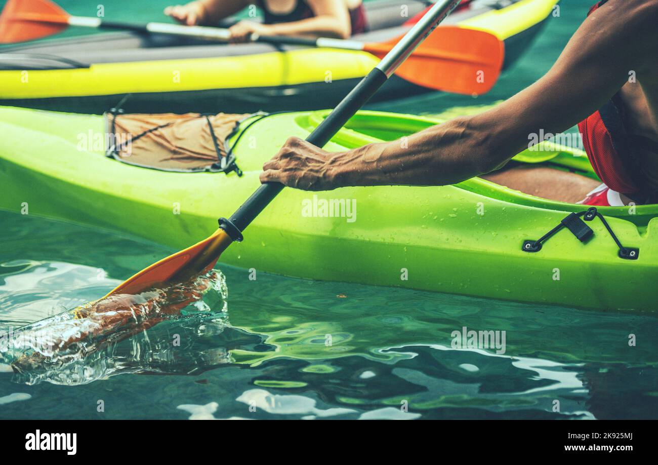 Caucasian Male Kayaker Paddling a Green Touring Kayak. Kayak Paddle ...