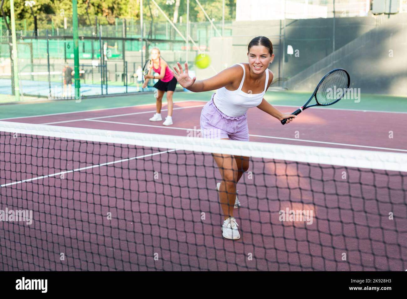 Young woman in shorts playing tennis on court Stock Photo - Alamy