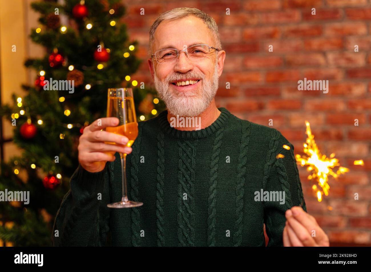 an elderly man in a green knitted sweater raising a toast with ...