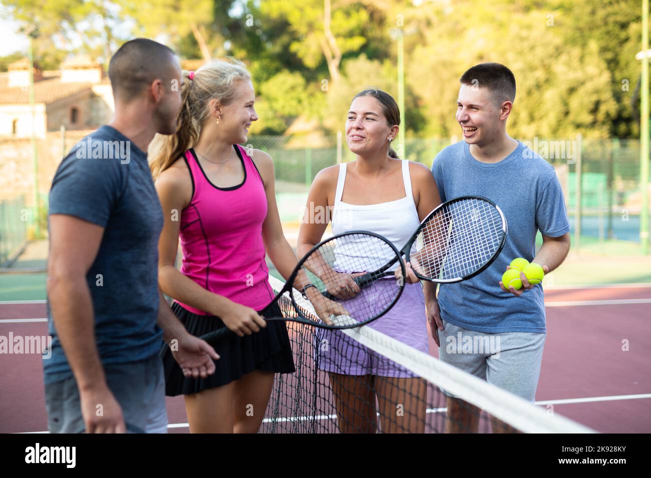 Four tennis players standing on court and talking about match Stock Photo - Alamy