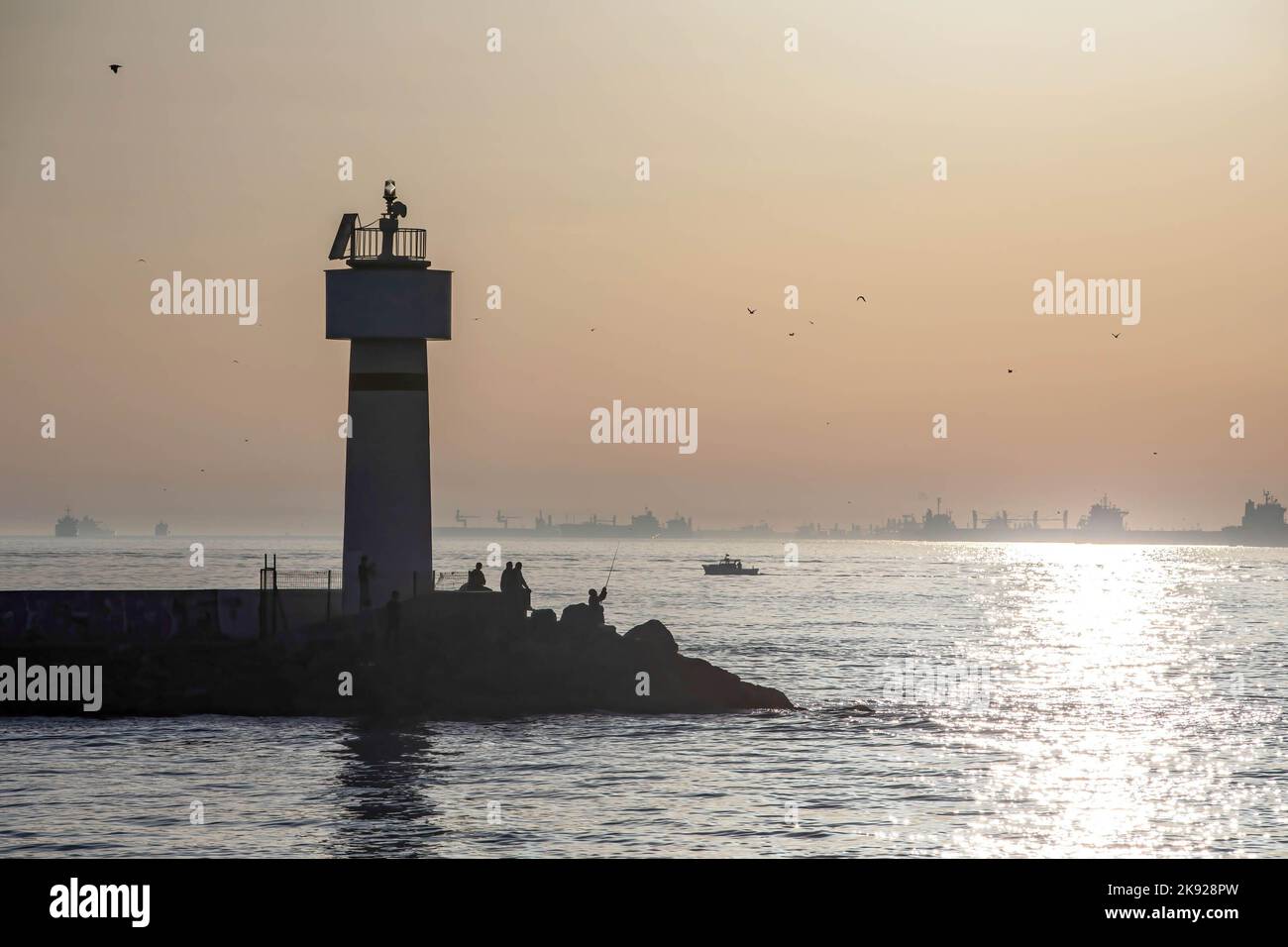 Silhouettes of people fishing seen at the Inciburnu lighthouse in ...