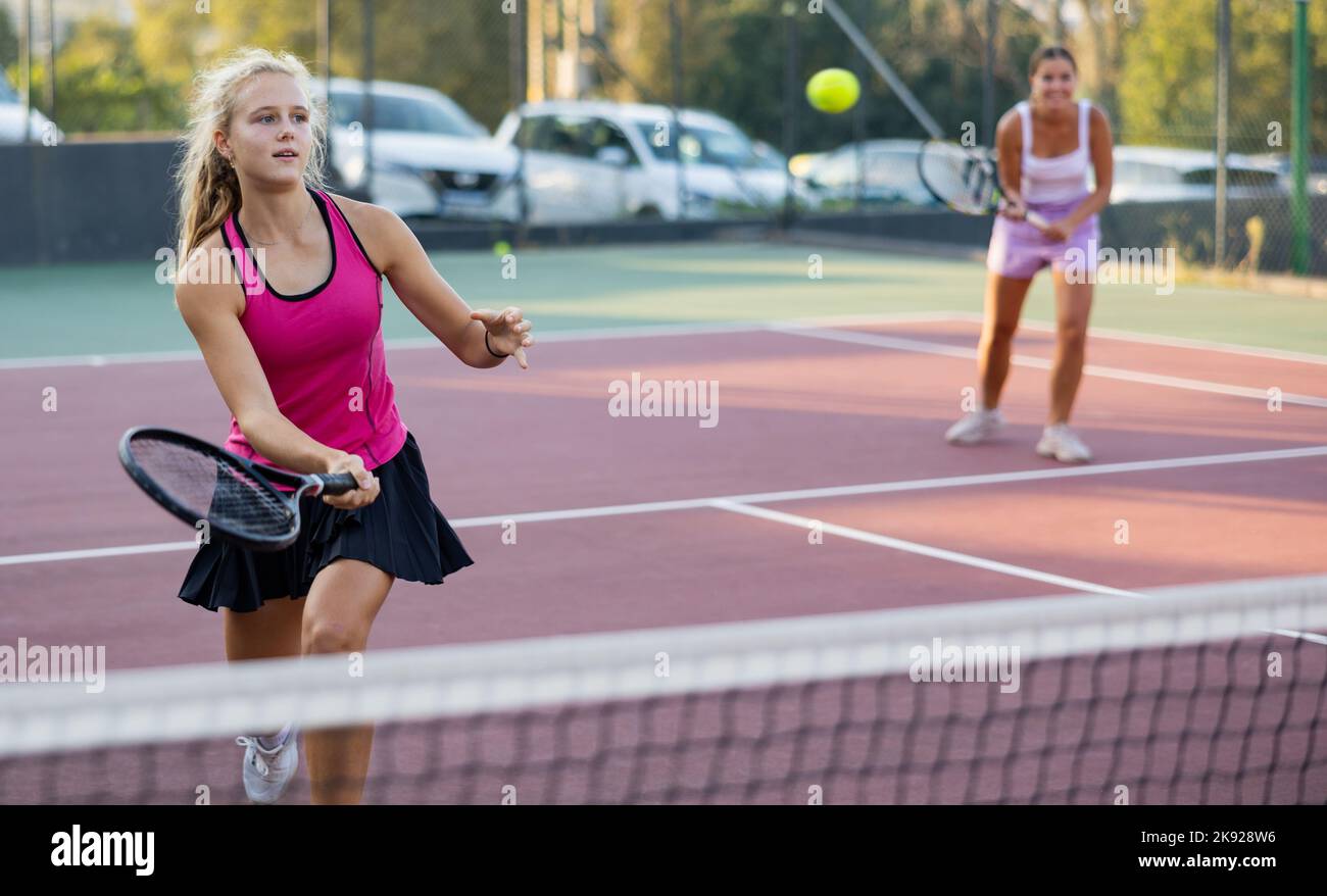 Sports active woman during friendly doubles couple match. Two women ...