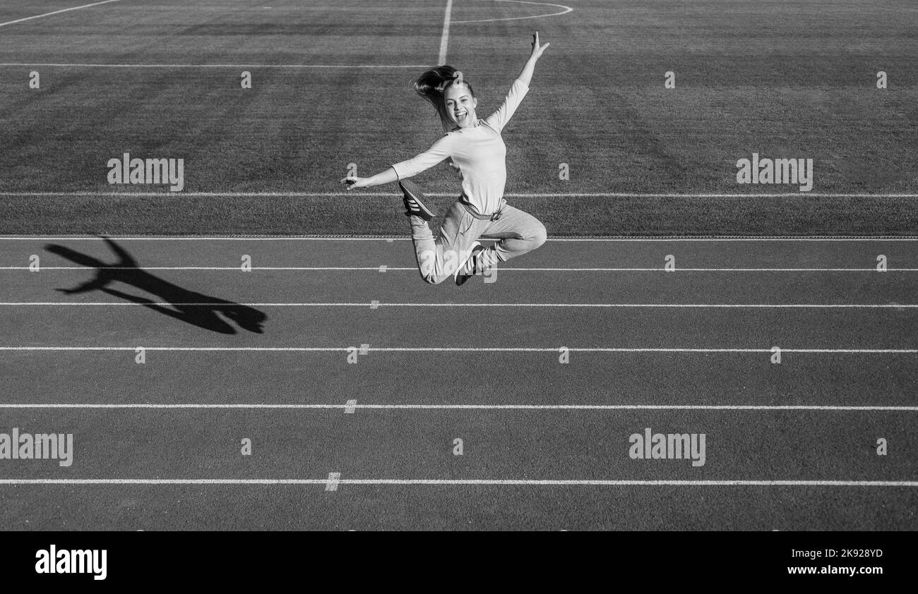 Happy energetic girl child jump on running track, athletics Stock Photo ...