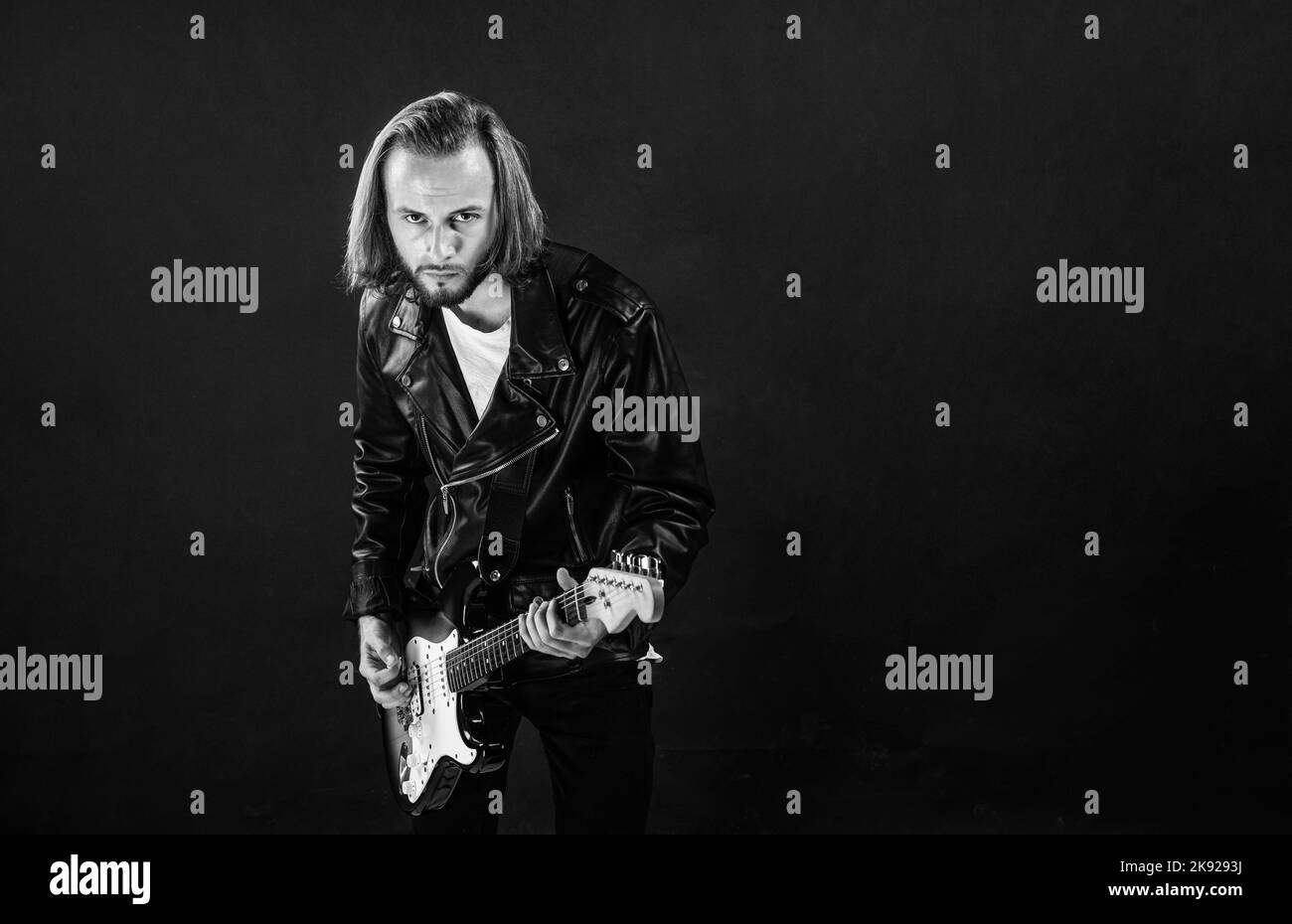 string musical instrument. copy space. bearded rocker in leather jacket ...