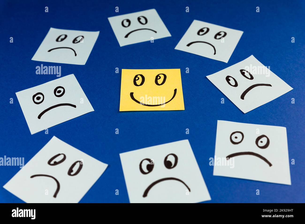 Sticky notes with hand drawn Smiley face and Sad faces on blue ...