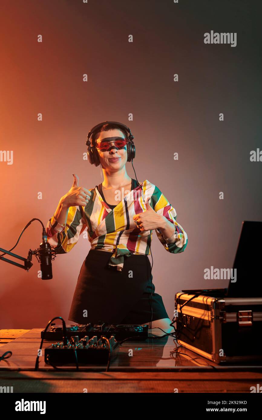 Female DJ doing thumbs up and like sign, showing approval symbol to ...