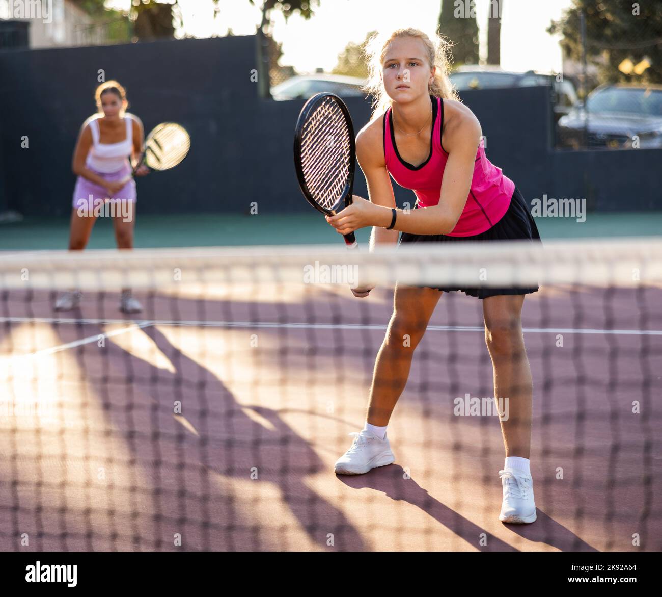 Female player playing tennis in tennis court outdoor behind net Stock ...