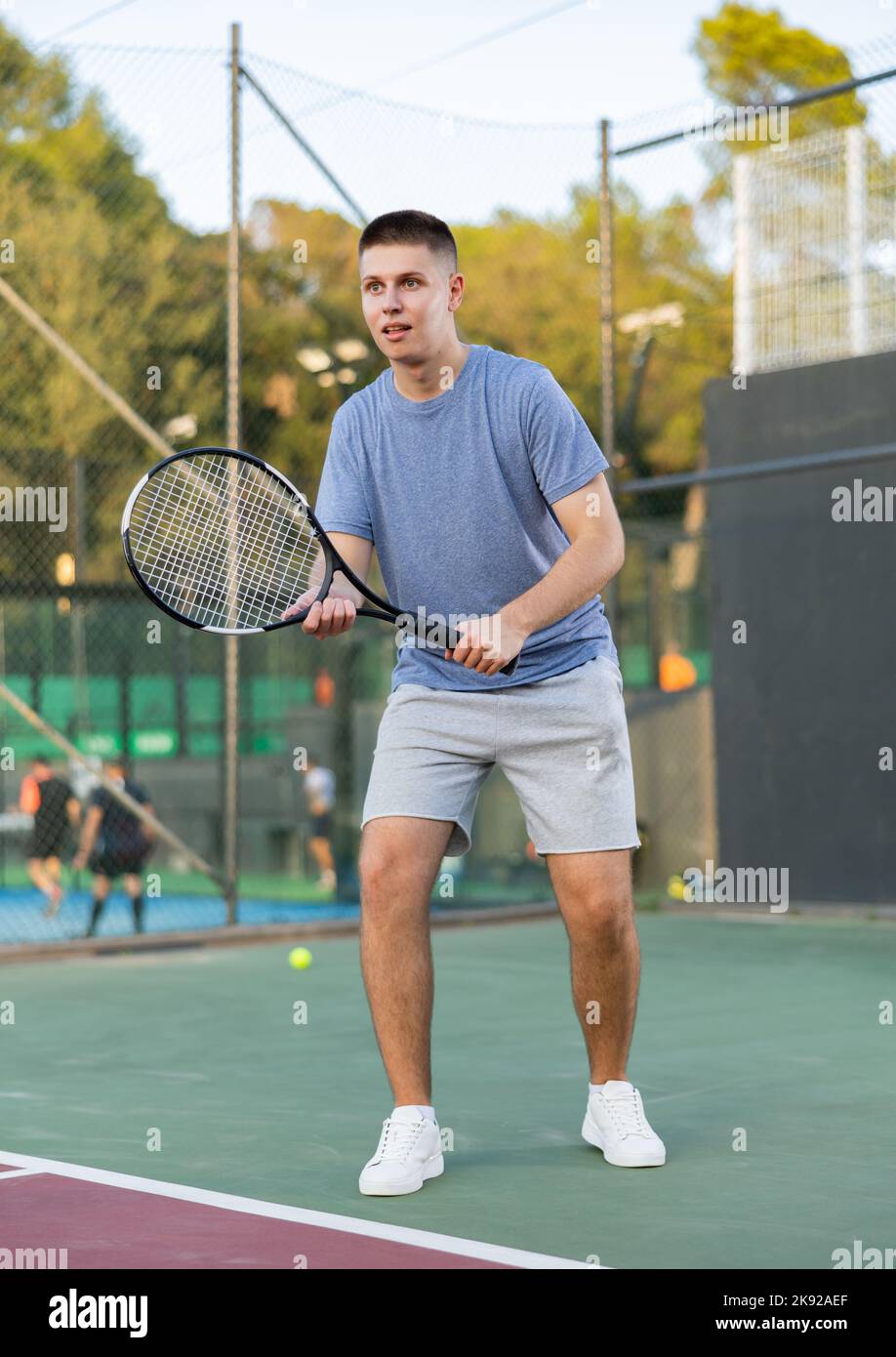 Concentrated young man tennis player hitting ball with racket Stock ...